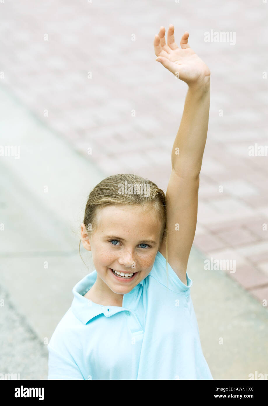Girl raising hand, smiling Stock Photo - Alamy
