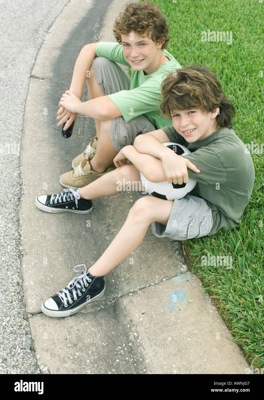 Suburban children sitting on curb Stock Photo - Alamy
