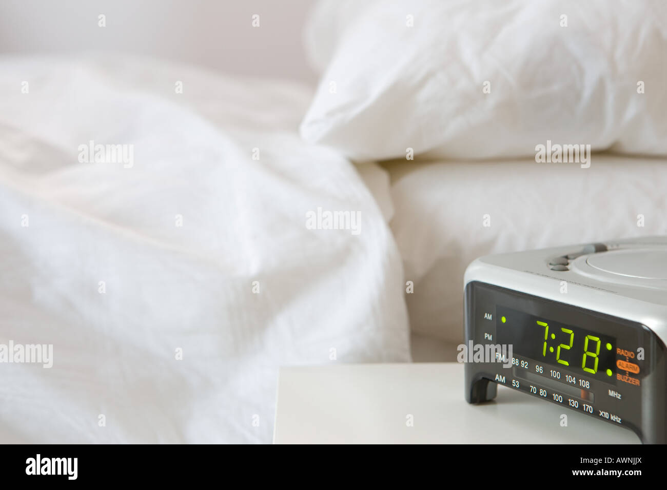 Alarm clock next to a bed Stock Photo - Alamy