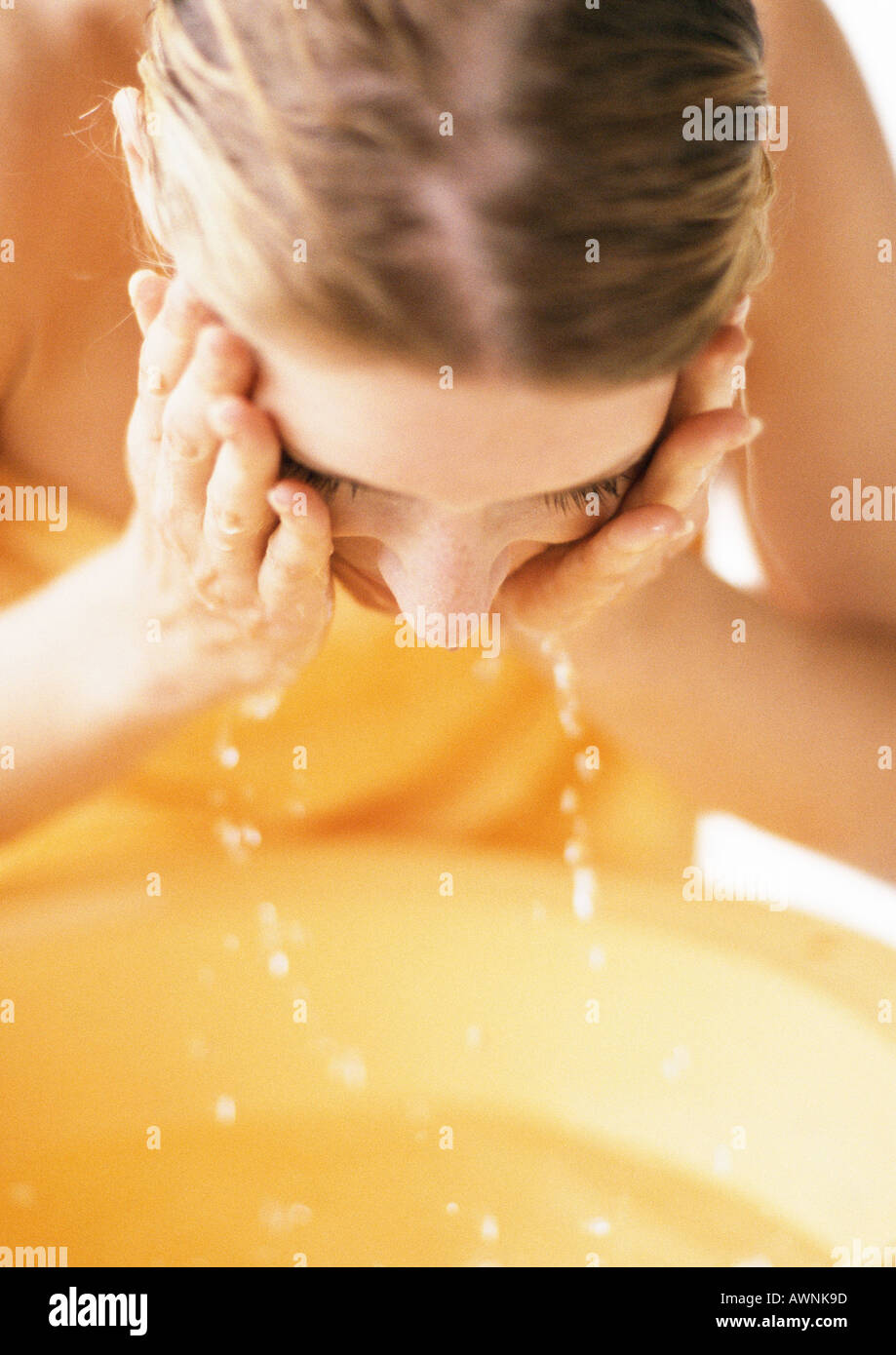 Woman leaning forward, washing face, close-up Stock Photo - Alamy