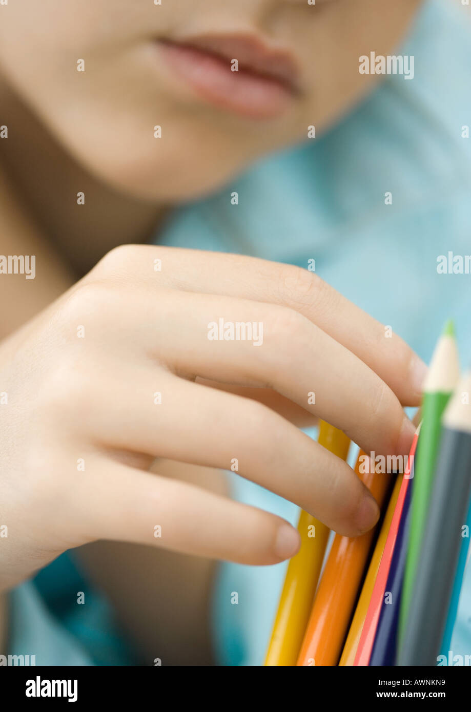 Child touching colored pencils Stock Photo - Alamy