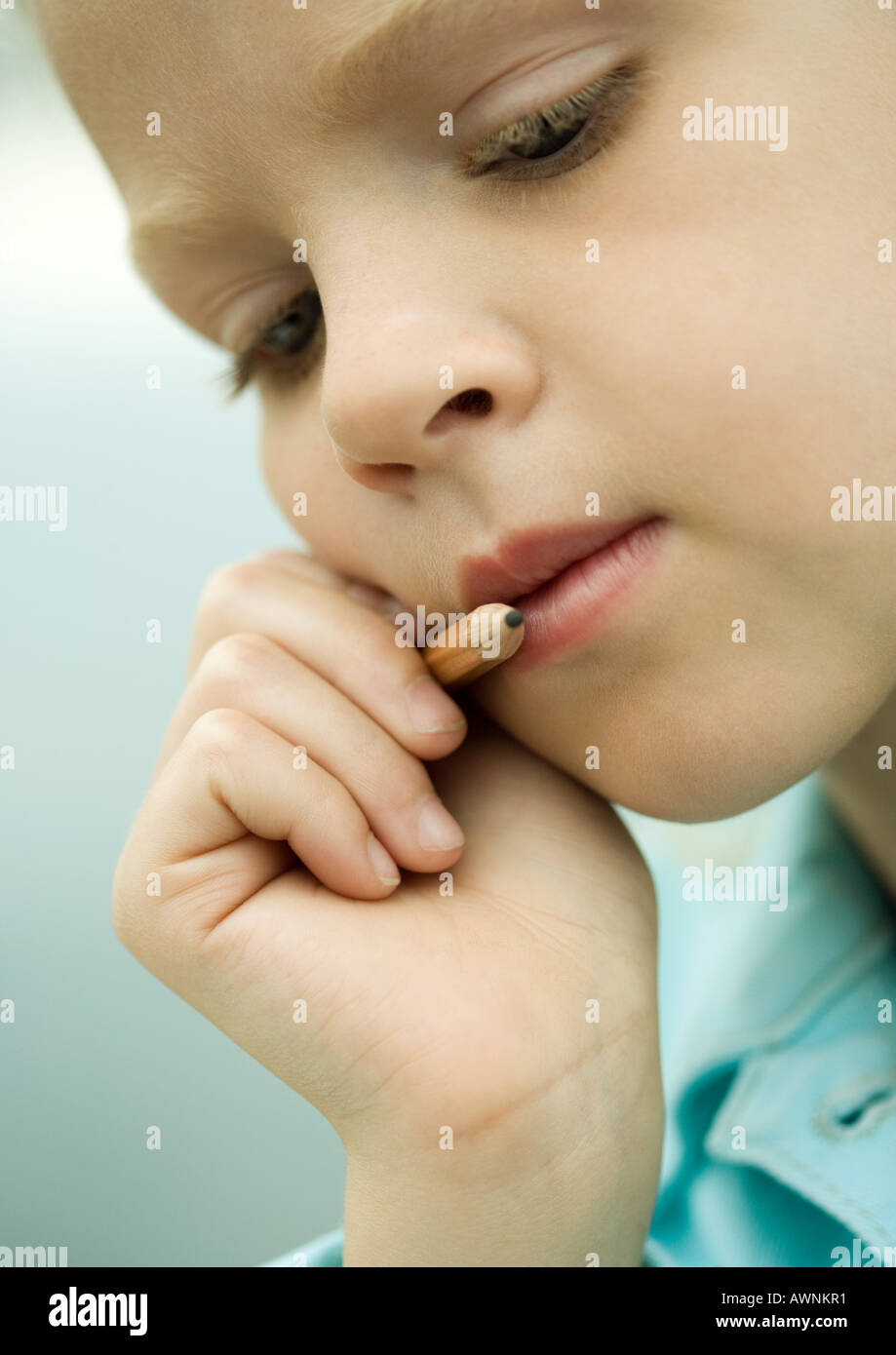 Girl thinking, holding pencil next to mouth Stock Photo - Alamy