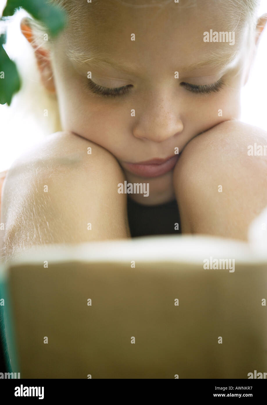 Girl reading book curled up hi-res stock photography and images - Alamy