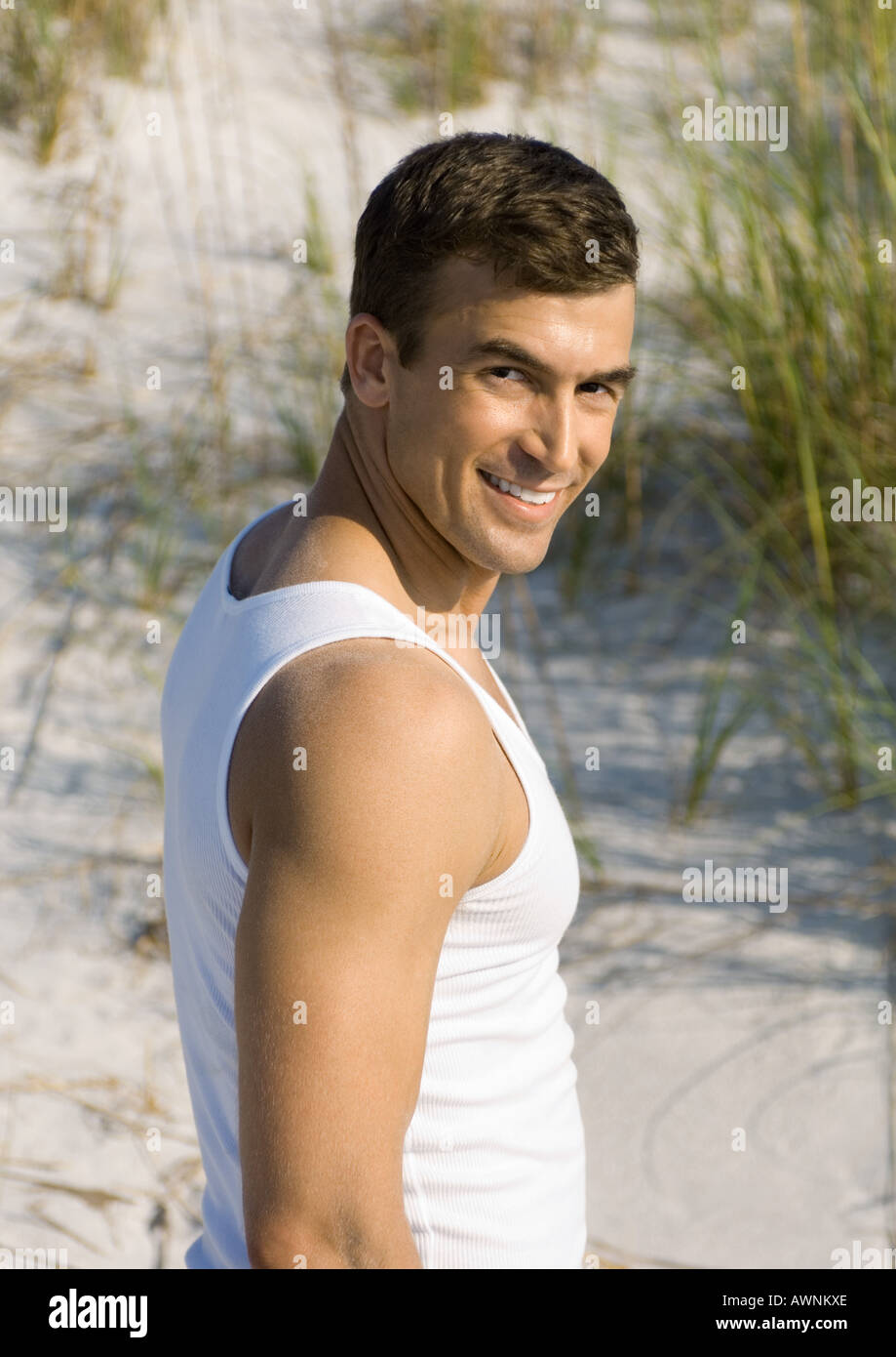 Man on beach, smiling at camera Stock Photo - Alamy