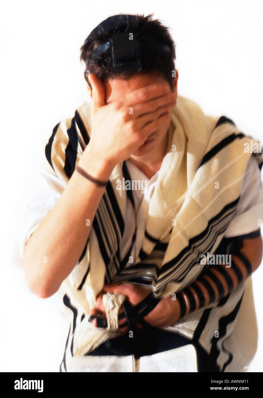 Jewish man wearing Tefillin and Tallith for prayer, covering face with ...