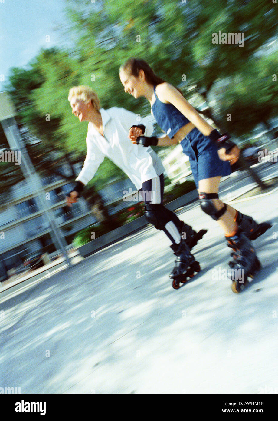 Mature woman and girl in-line skating, blurred Stock Photo - Alamy