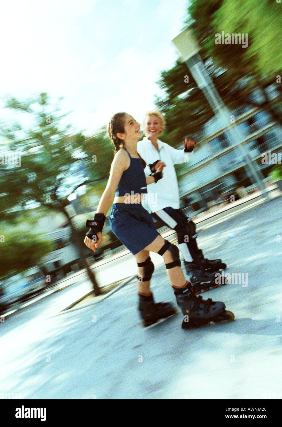 Mature woman and young girl in-line skating, blurred Stock Photo - Alamy
