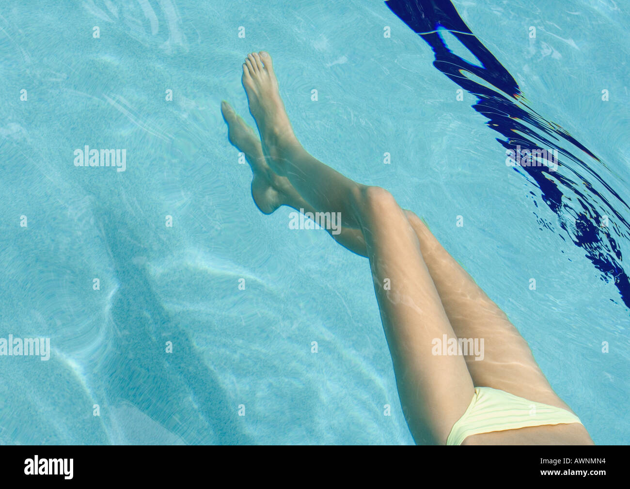 Woman floating in pool, view from waist down Stock Photo - Alamy