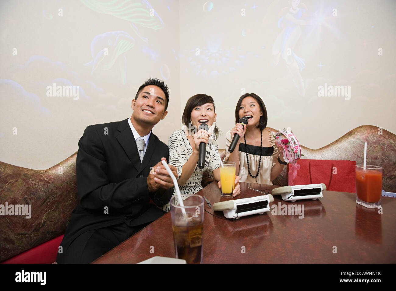 Friends singing karaoke Stock Photo - Alamy
