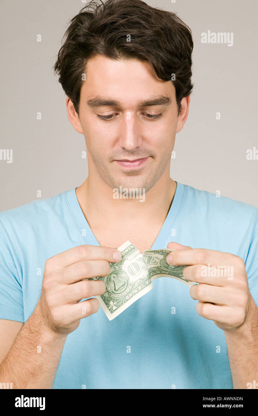 Man ripping a dollar Stock Photo - Alamy
