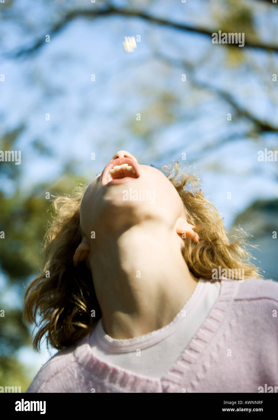 Girl catching popcorn with mouth Stock Photo - Alamy