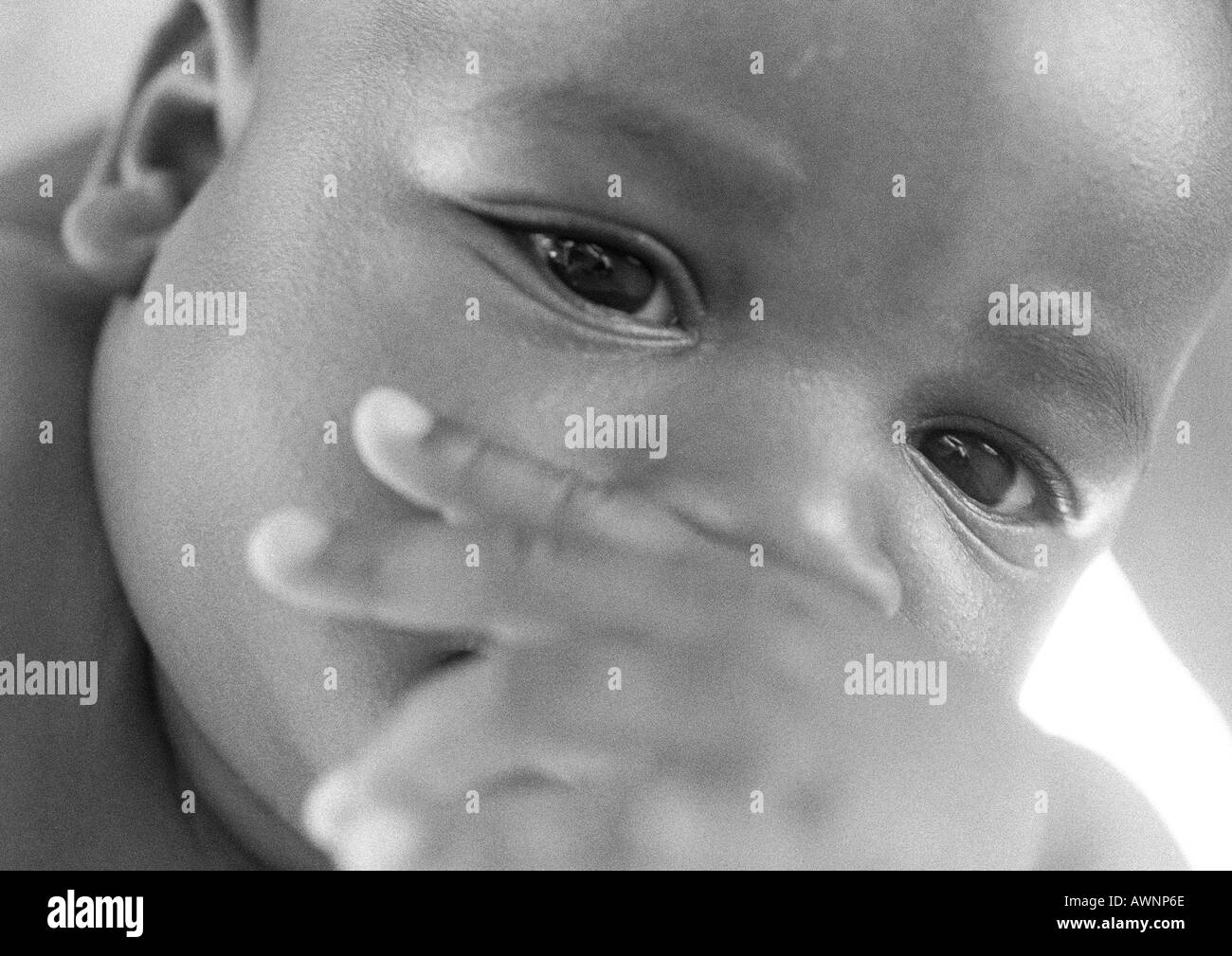Baby with hand in front of mouth, close-up Stock Photo - Alamy