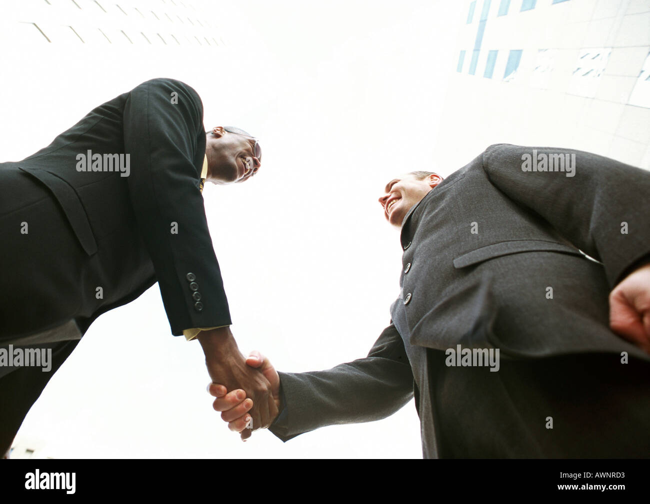 Two businessmen shaking hands, low angle view Stock Photo - Alamy