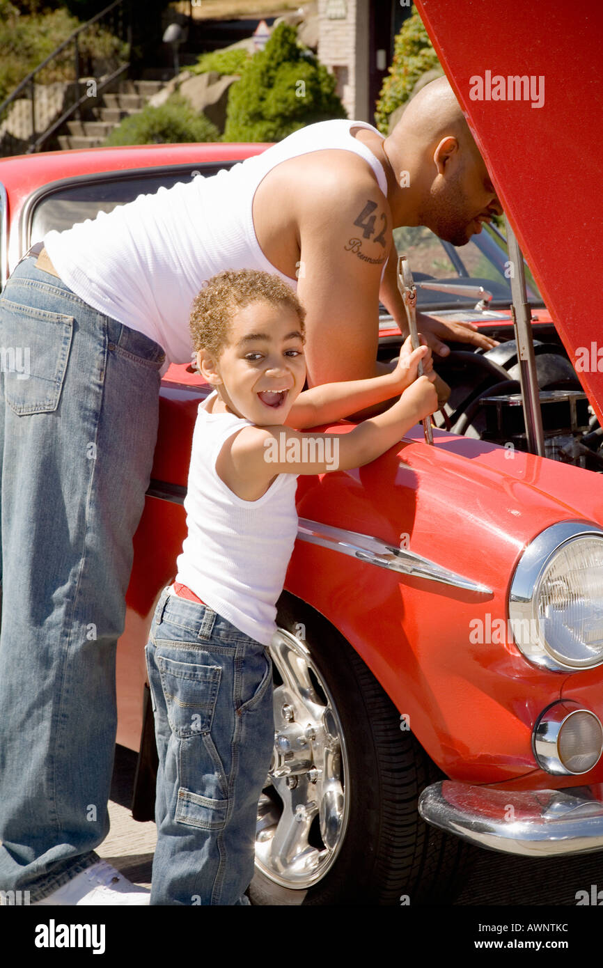 Young boy holding tools for his mechanic father Stock Photo - Alamy
