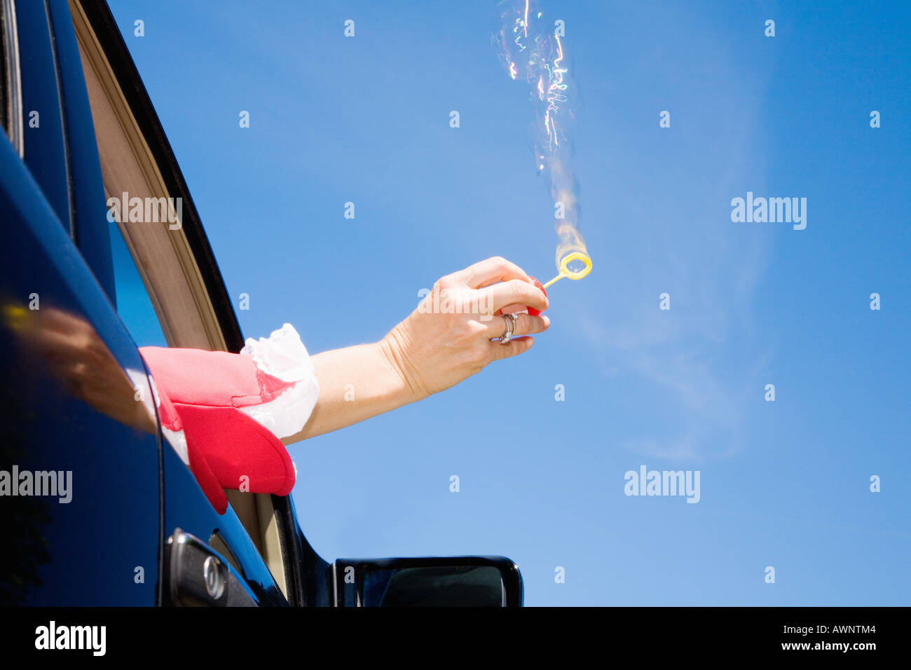 Woman blowing bubbles out car window Stock Photo - Alamy