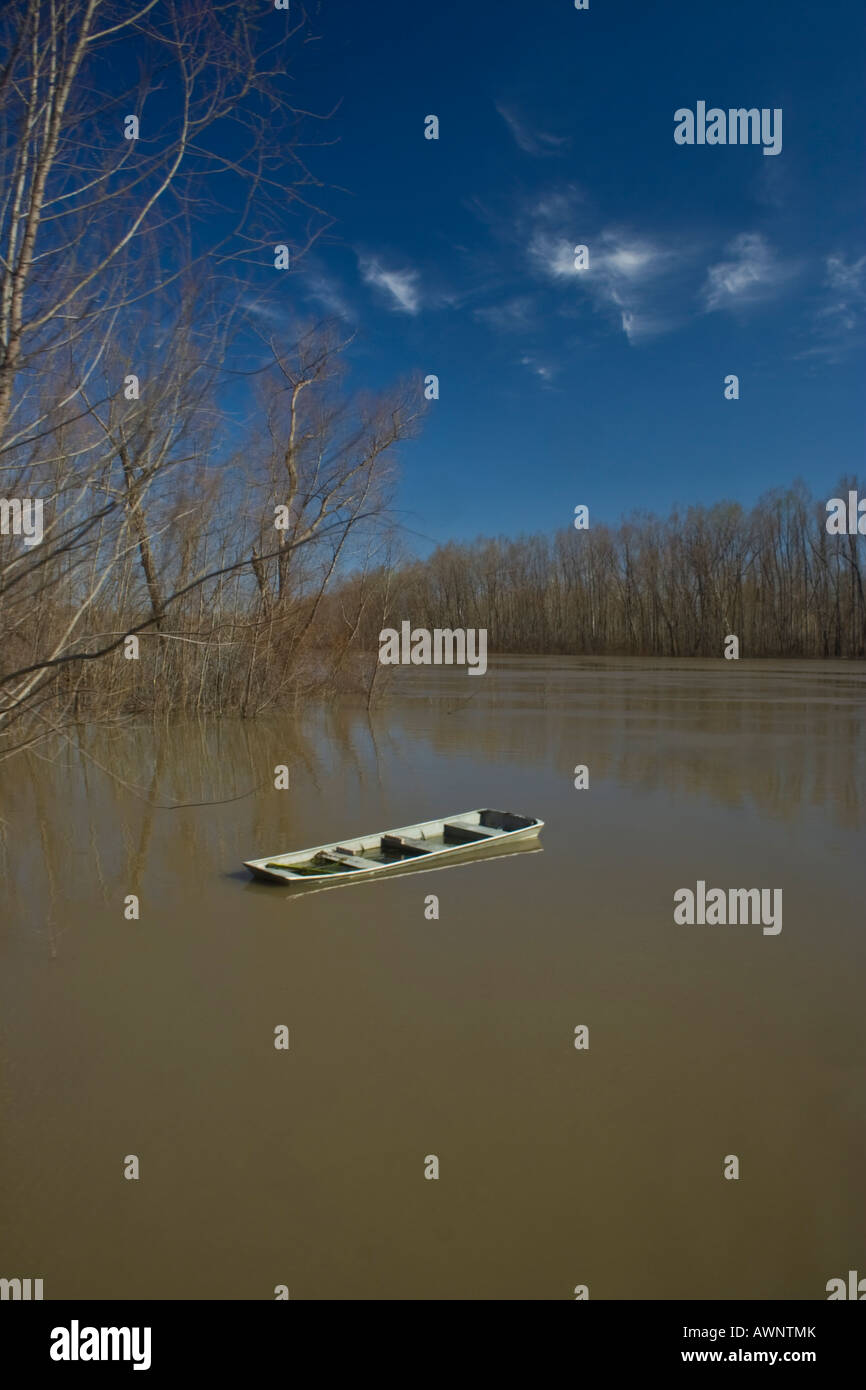 flooded river with boat full of water Stock Photo - Alamy