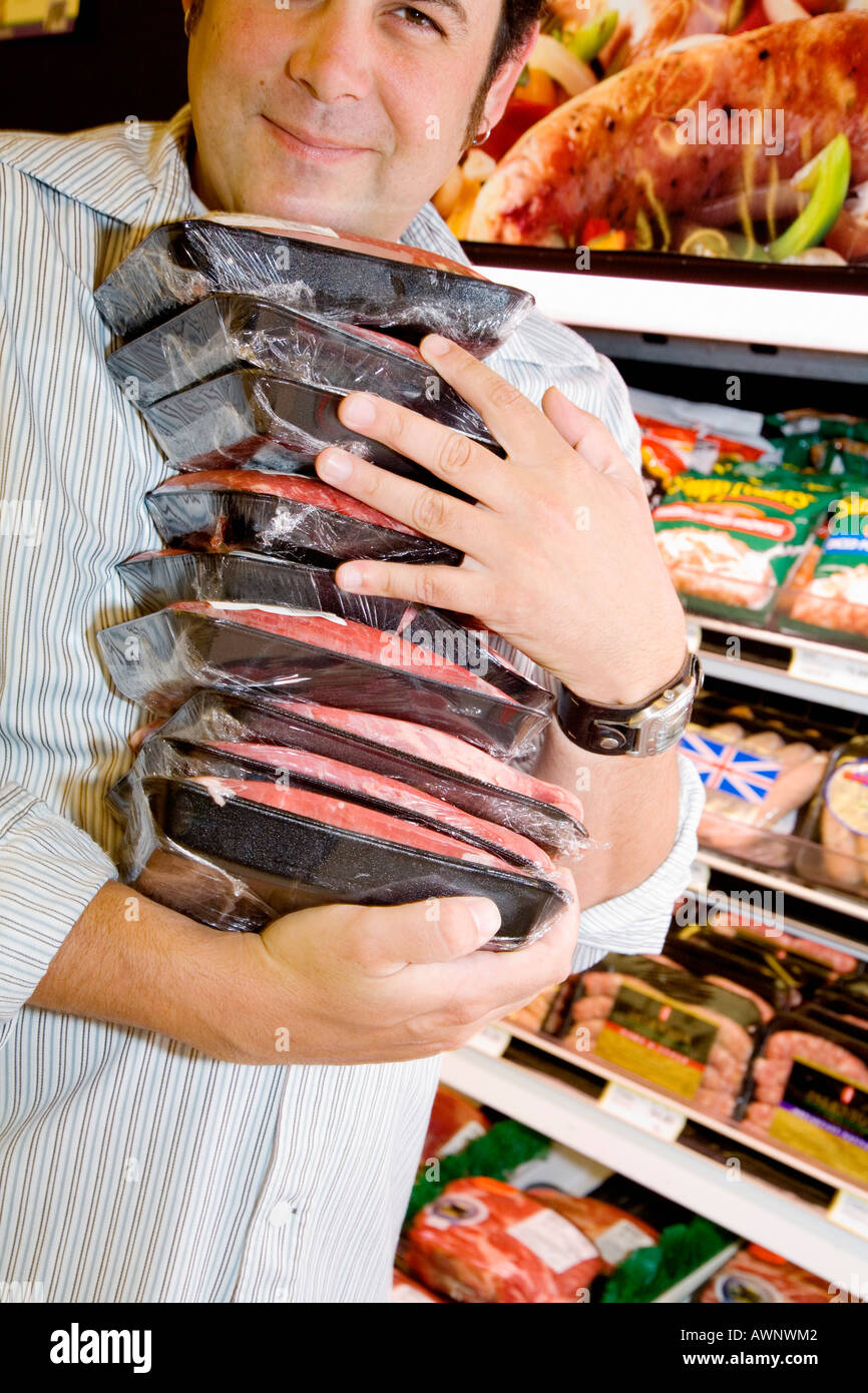 Man carrying packages of raw meat Stock Photo - Alamy