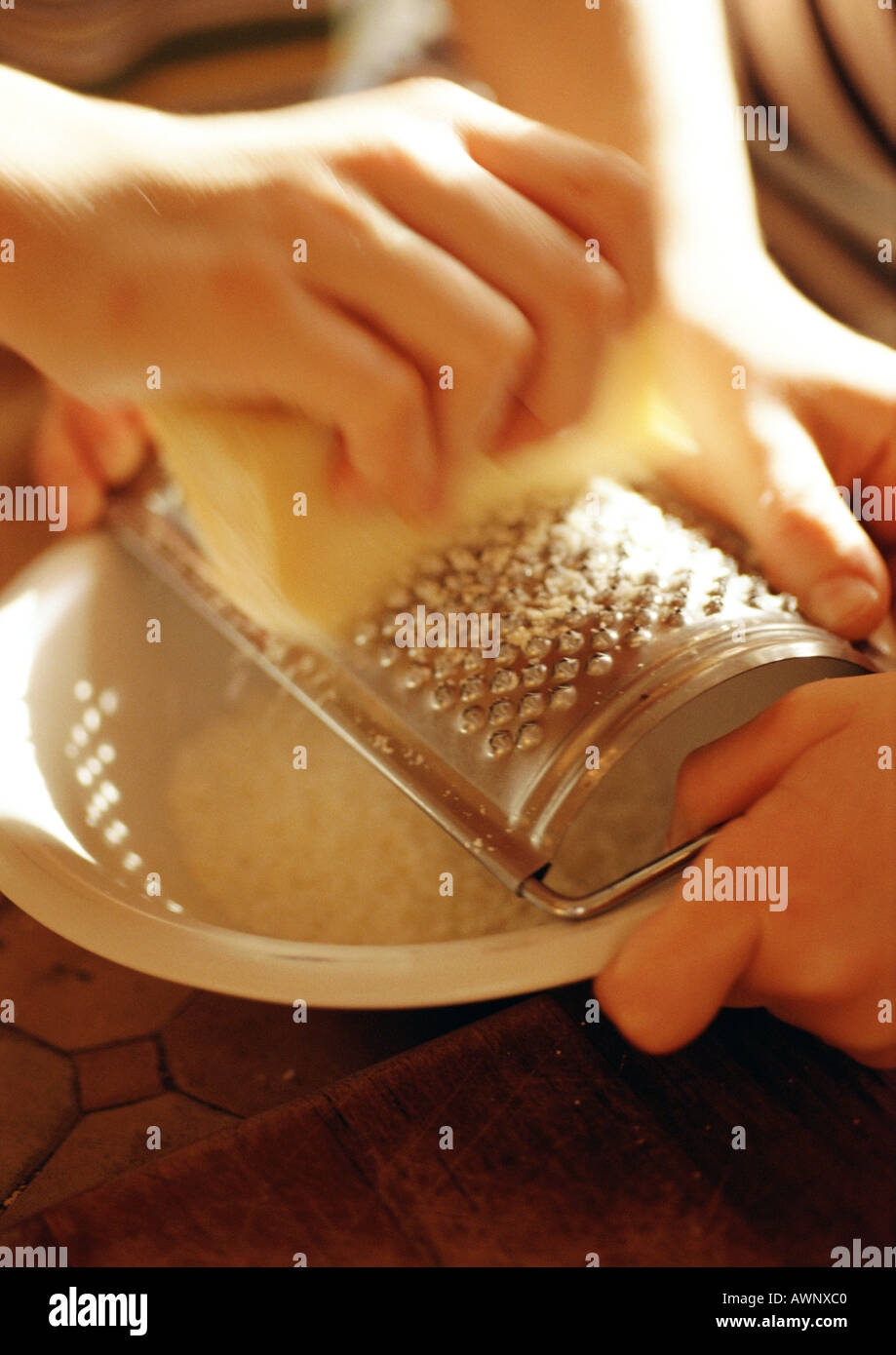 Hands grating cheese over bowl, close-up Stock Photo - Alamy