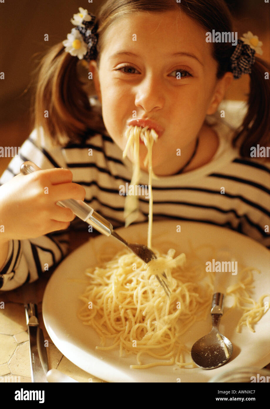 Child eating spaghetti, smiling at camera Stock Photo - Alamy