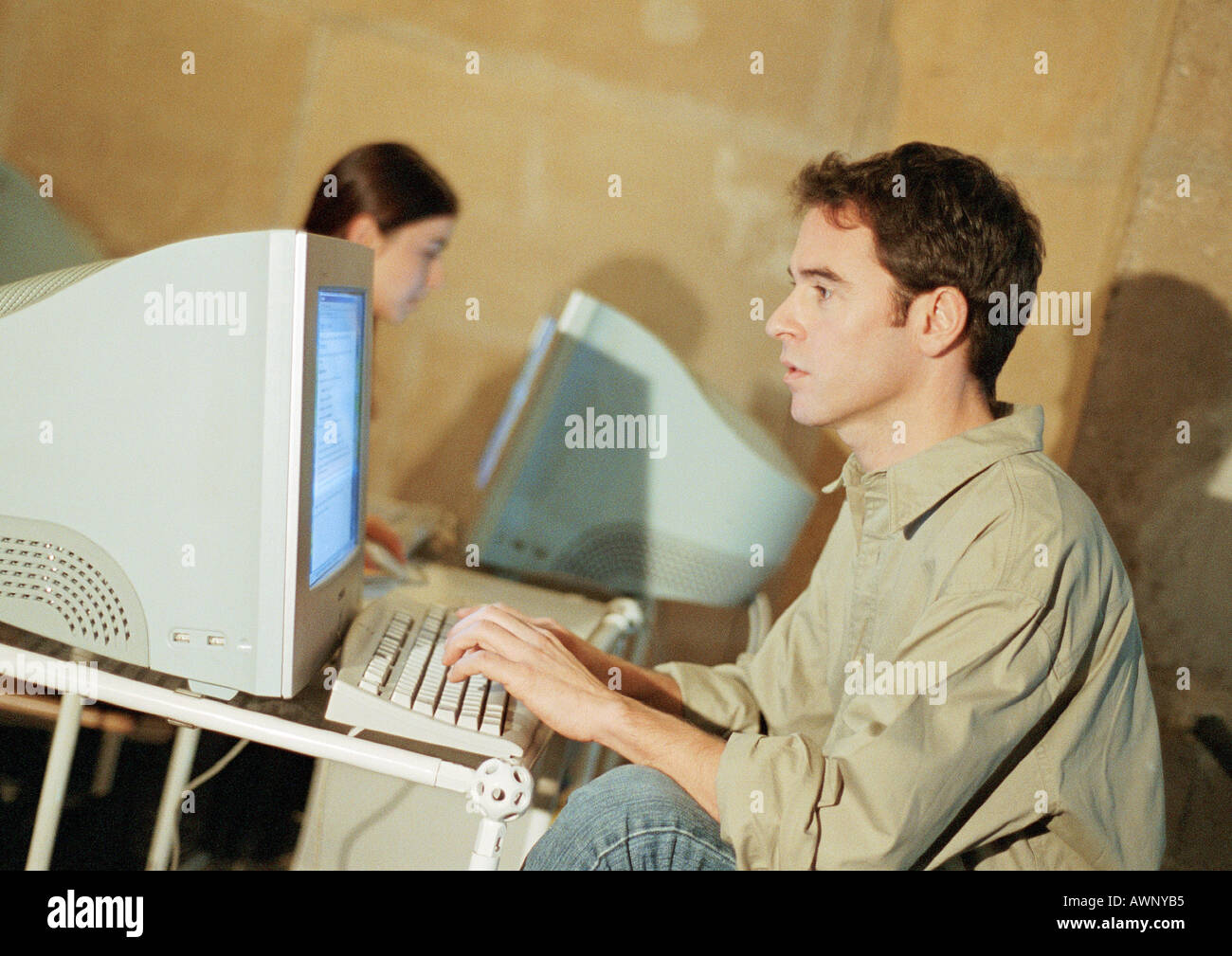 Man and woman working on computers Stock Photo - Alamy