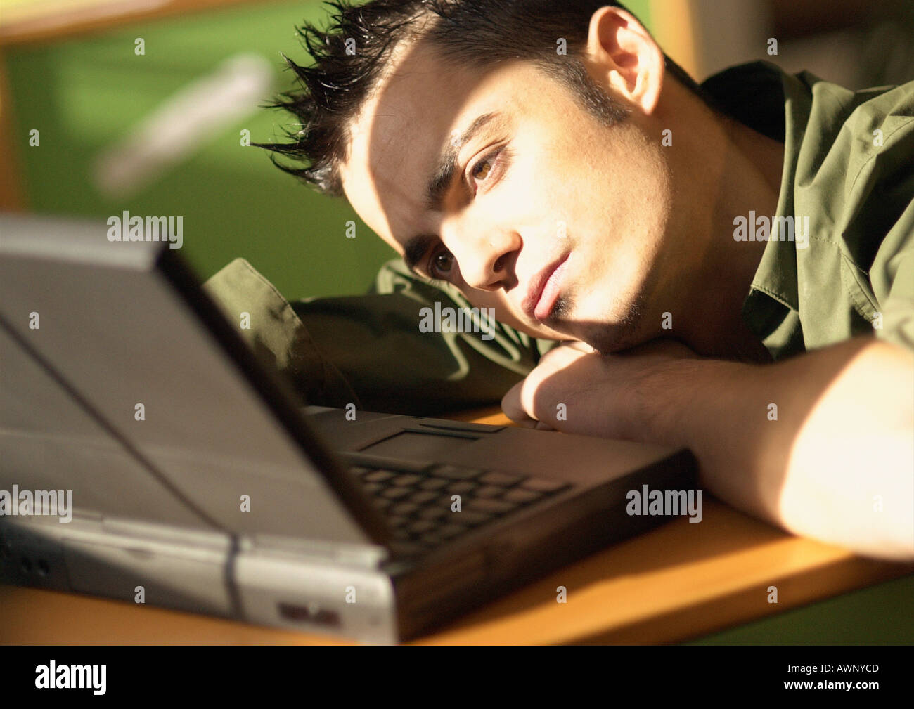 Man leaning looking at laptop computer Stock Photo - Alamy