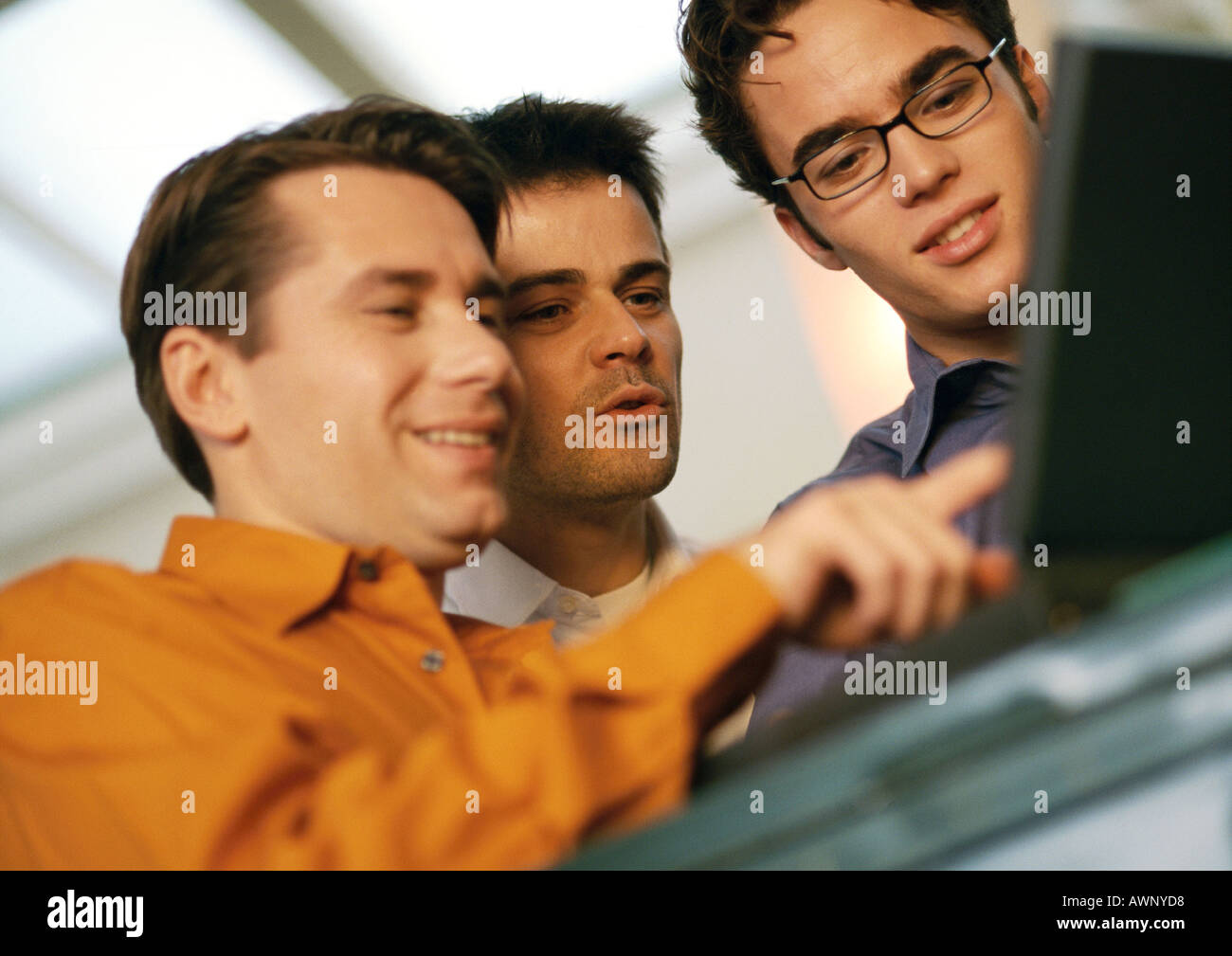 Three men looking at laptop Stock Photo - Alamy