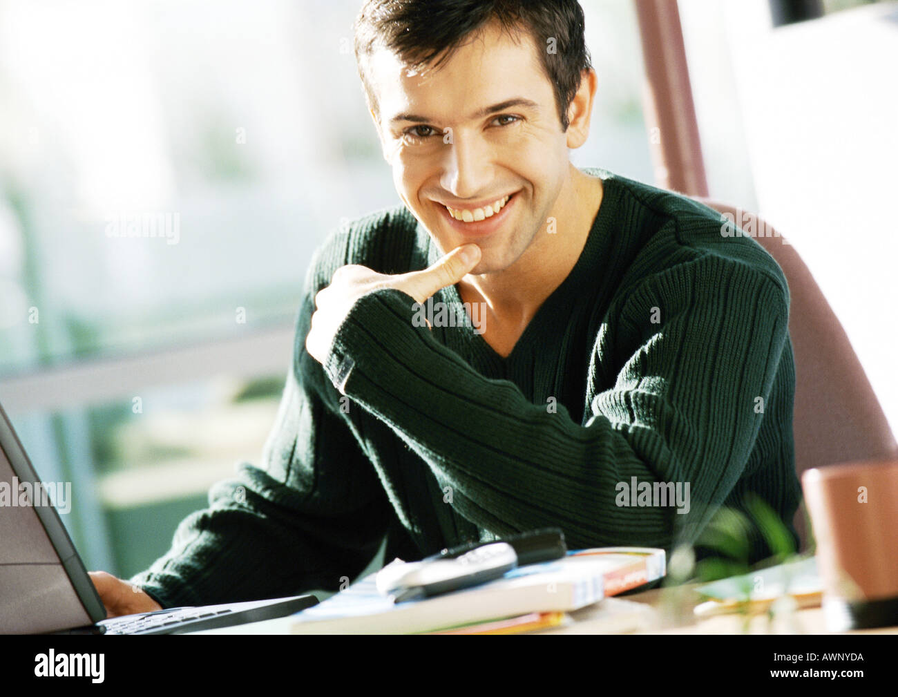 Man with hand on laptop computer, smiling, portrait Stock Photo - Alamy