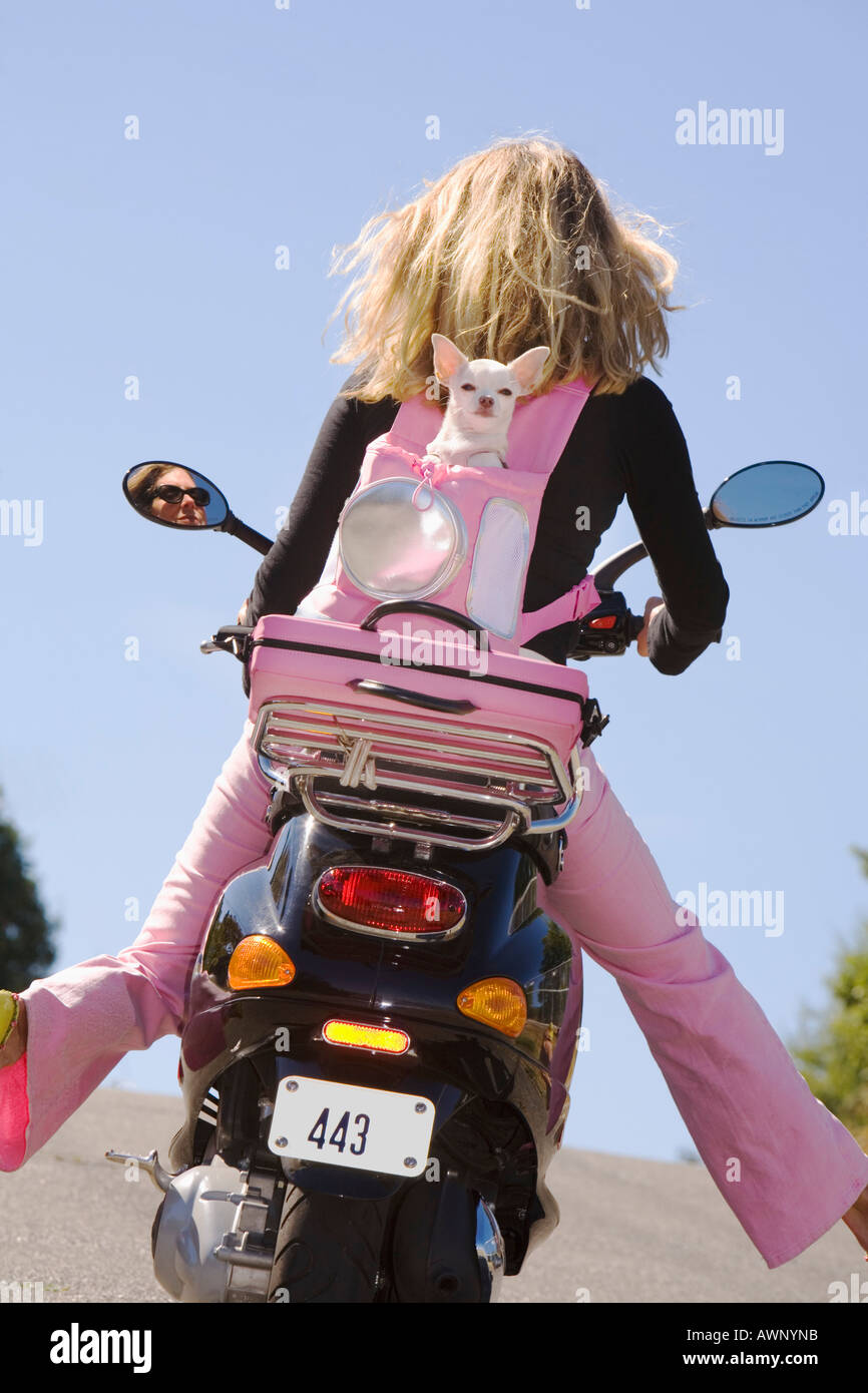 Woman riding a scooter with extended legs Stock Photo - Alamy