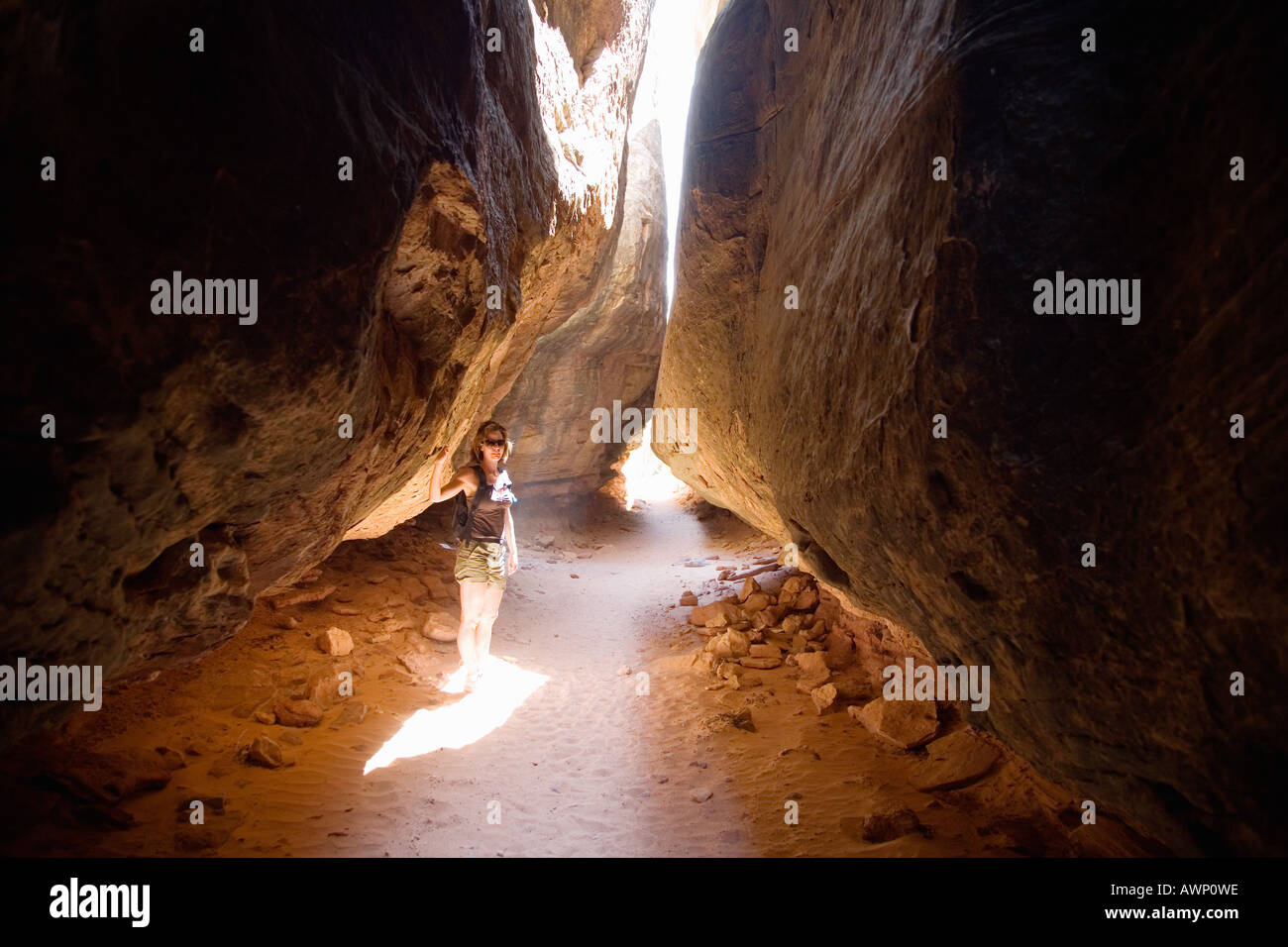 Woman standing under crevice in cave Stock Photo - Alamy