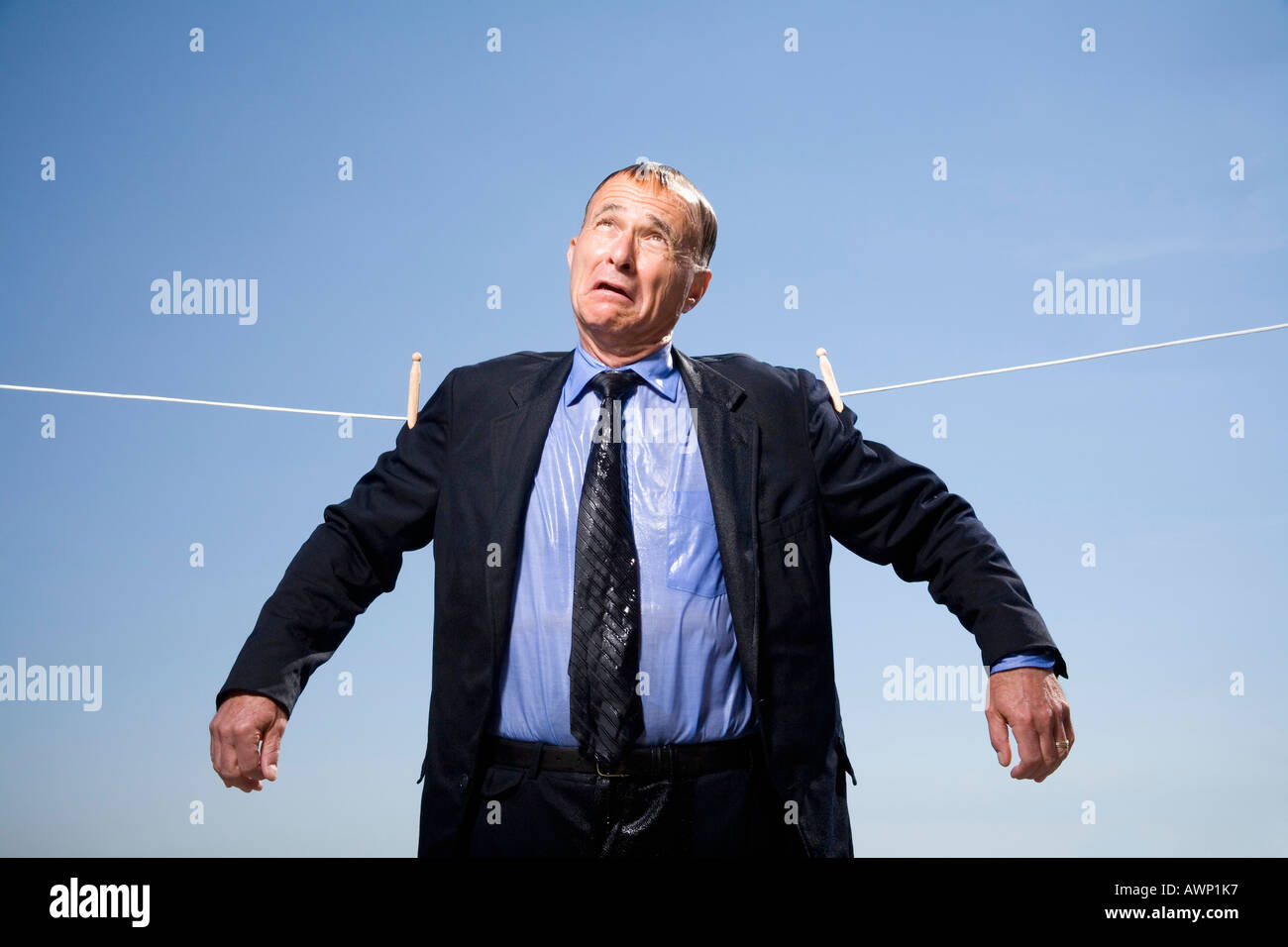 Businessman hung out to dry Stock Photo - Alamy