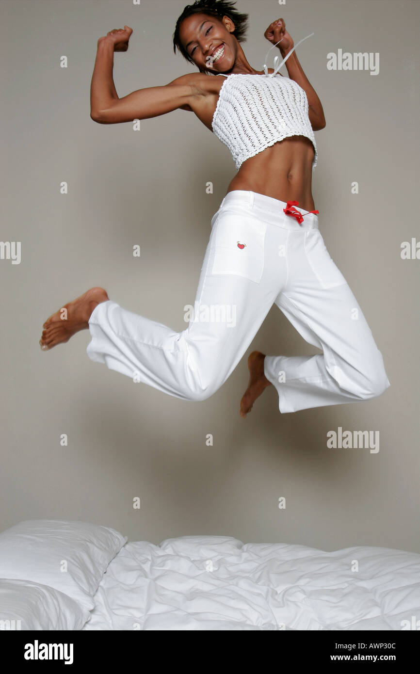 Woman jumping on bed Stock Photo - Alamy