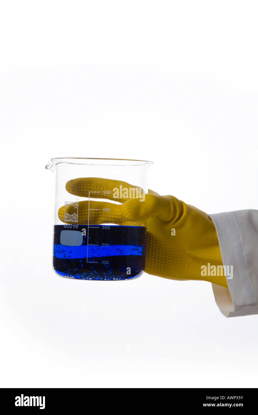 Hand holding a beaker containing blue liquid Stock Photo - Alamy