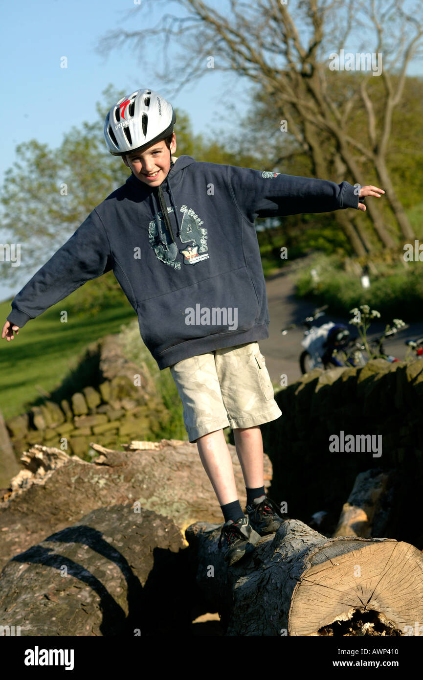 BOY BALANCING ON FELLED TREE TRUNK Stock Photo - Alamy