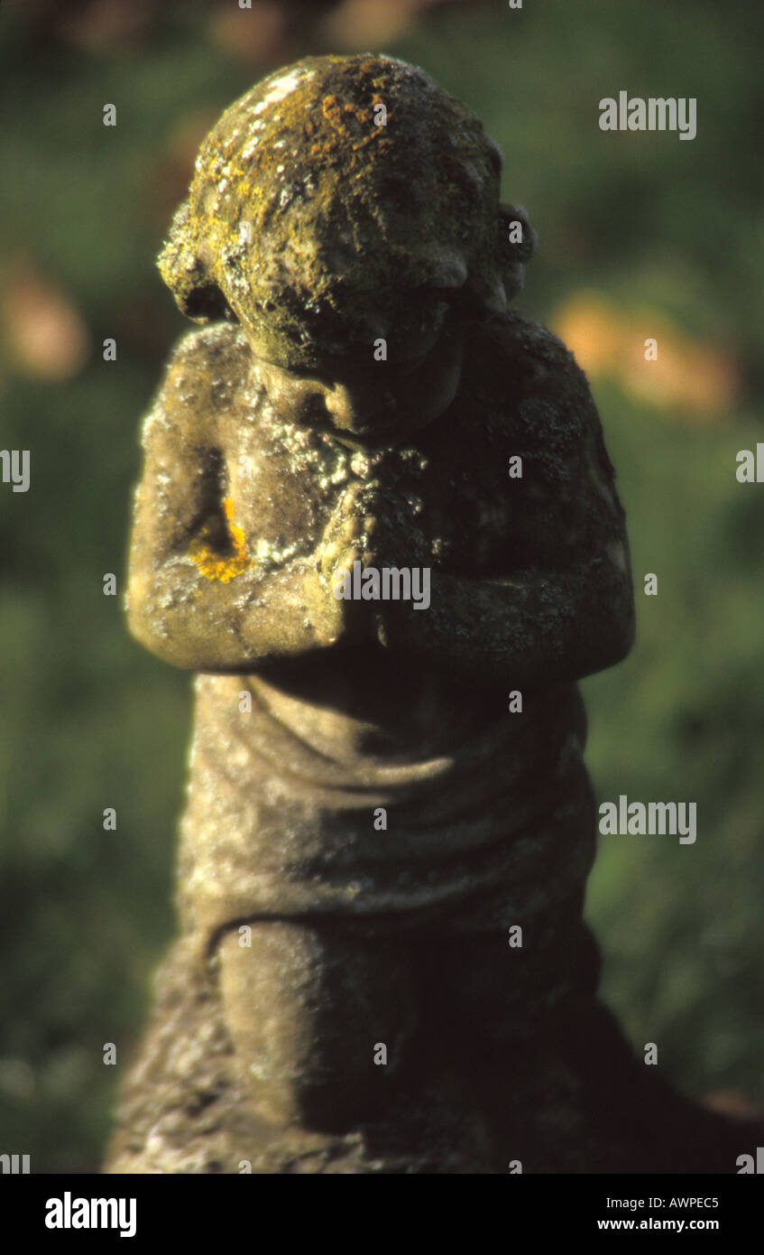 Gravestone statue of a child angel preying in the graveyard of Stoke D ...