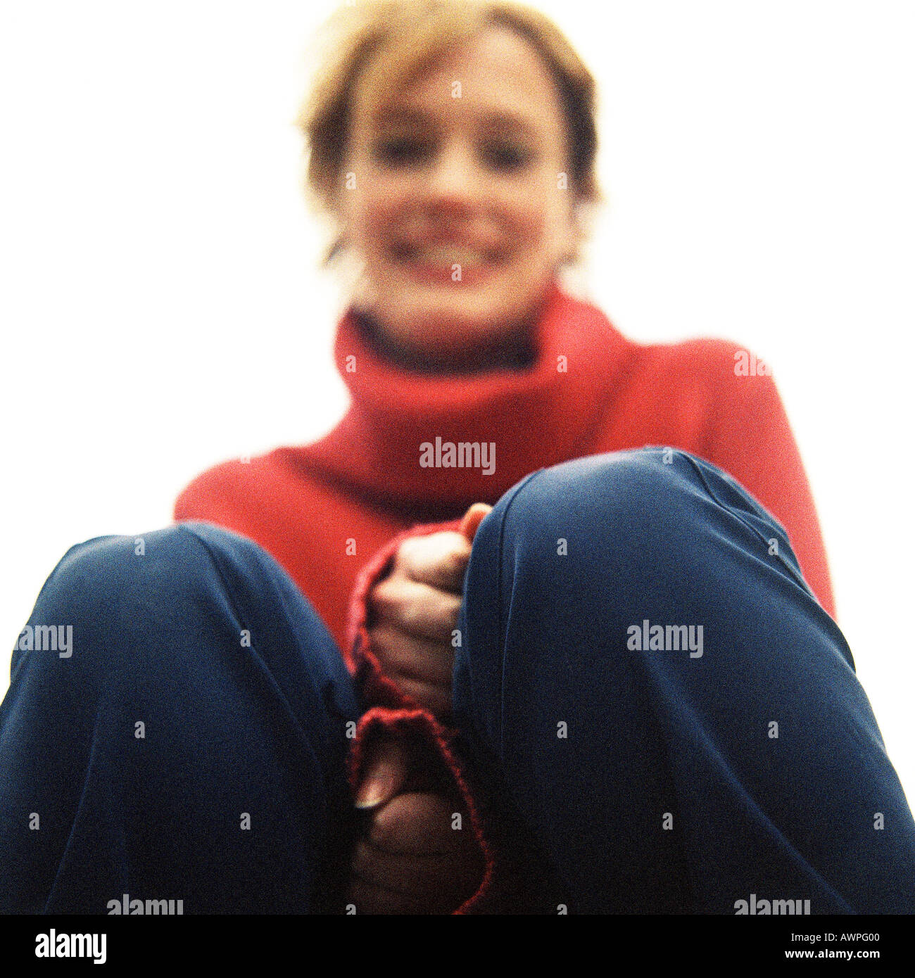 Young woman sitting, low angle view, portrait, blurred Stock Photo - Alamy