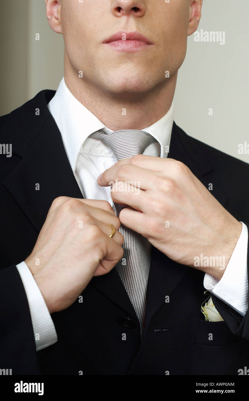 Groom fixing his tie Stock Photo - Alamy