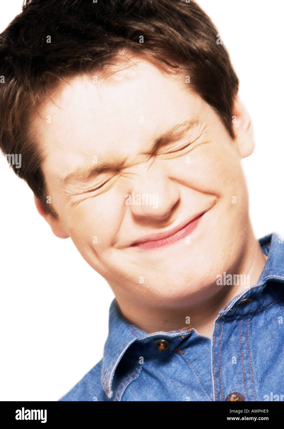 Teenage boy squinting eyes shut, close-up, portrait Stock Photo - Alamy