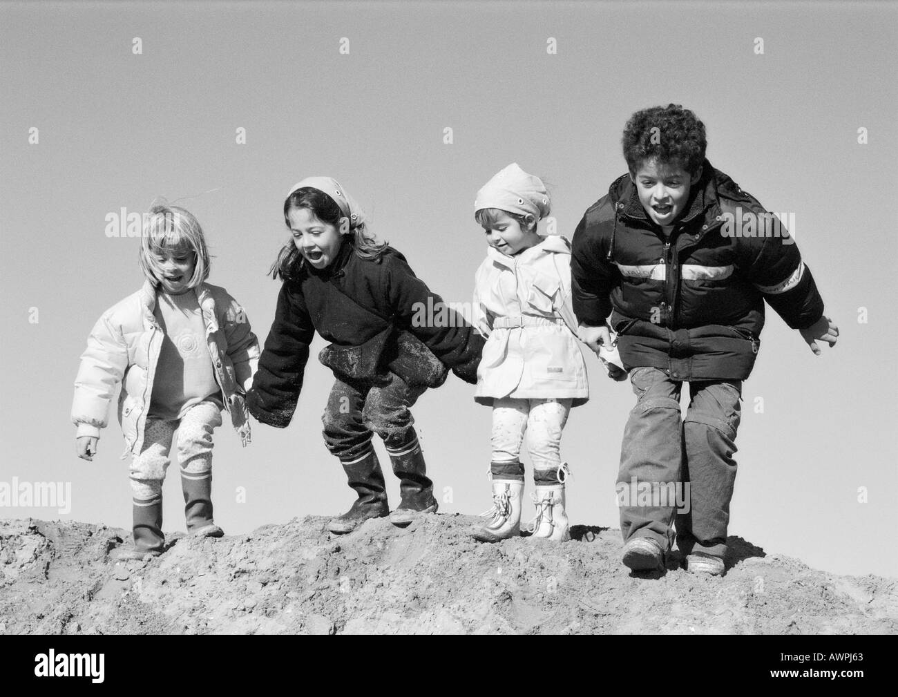 Three girls and boy holding hands, preparing to jump, b&w Stock Photo ...