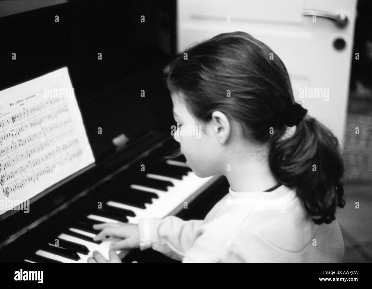 Girl playing piano, side view, b&w Stock Photo - Alamy