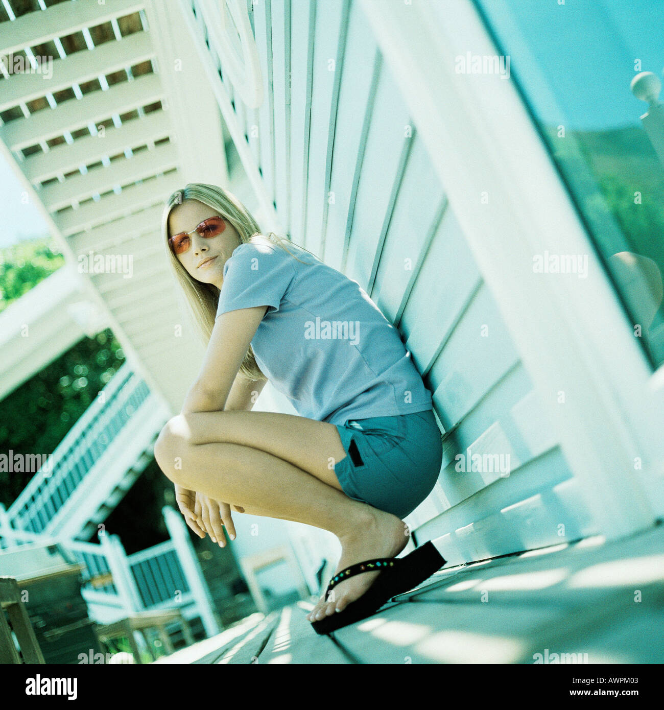 Young woman leaning back against outside wall, low angle view Stock ...