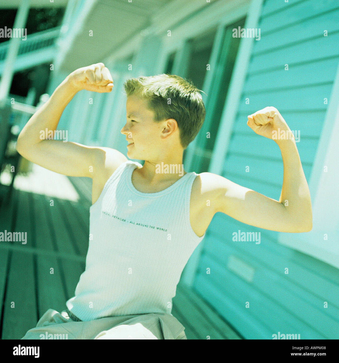 Teenage boy flexing arm muscles Stock Photo - Alamy