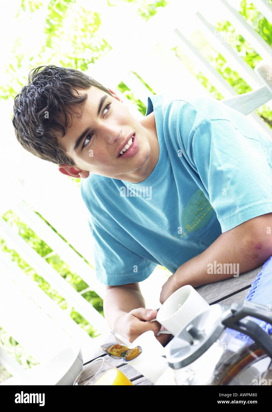 Teenage boy having breakfast outside, portrait Stock Photo - Alamy
