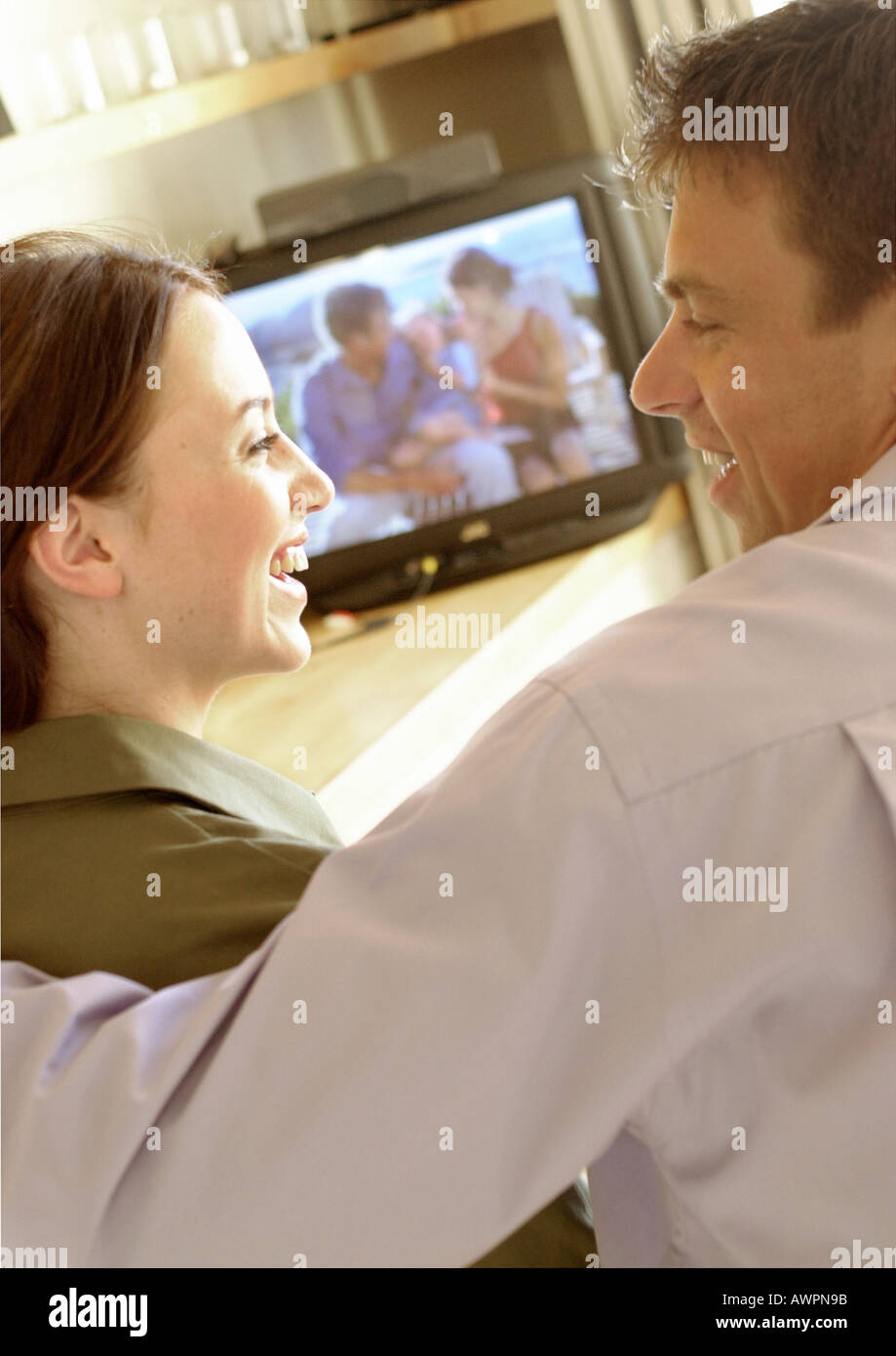 Couple side by side in front of television, smiling, close-up, rear ...