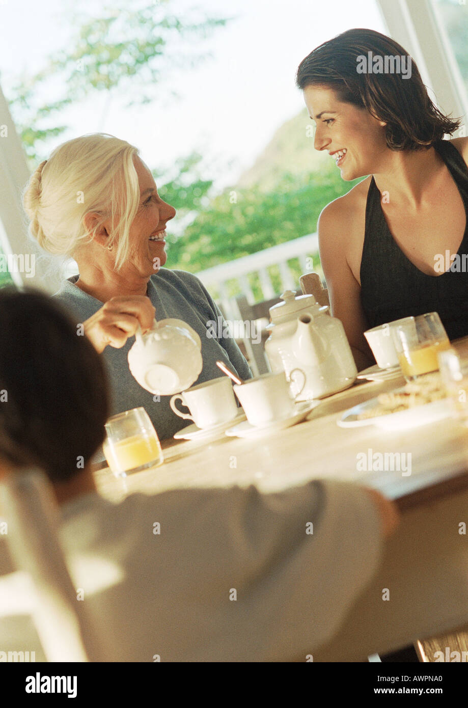 Two women and child having breakfast, side view Stock Photo - Alamy