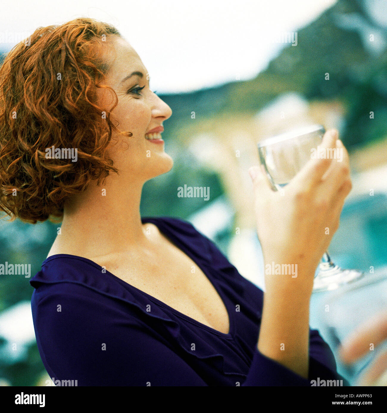 Woman holding glass, side view, portrait Stock Photo - Alamy
