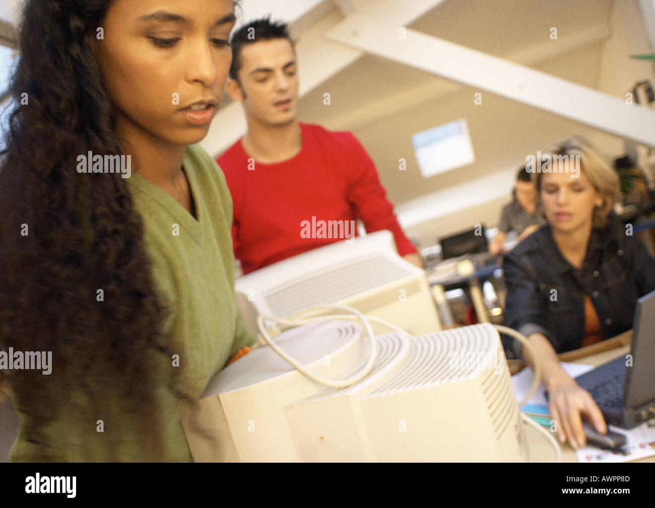 Man and woman carrying computer monitors in office Stock Photo - Alamy