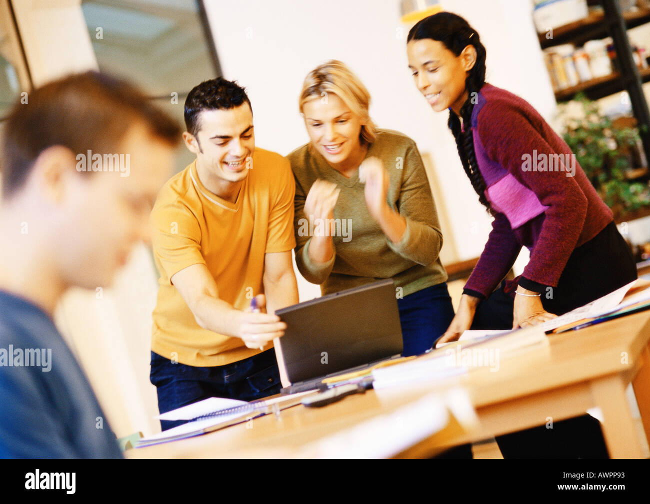 People in office, three people looking at laptop computer Stock Photo ...