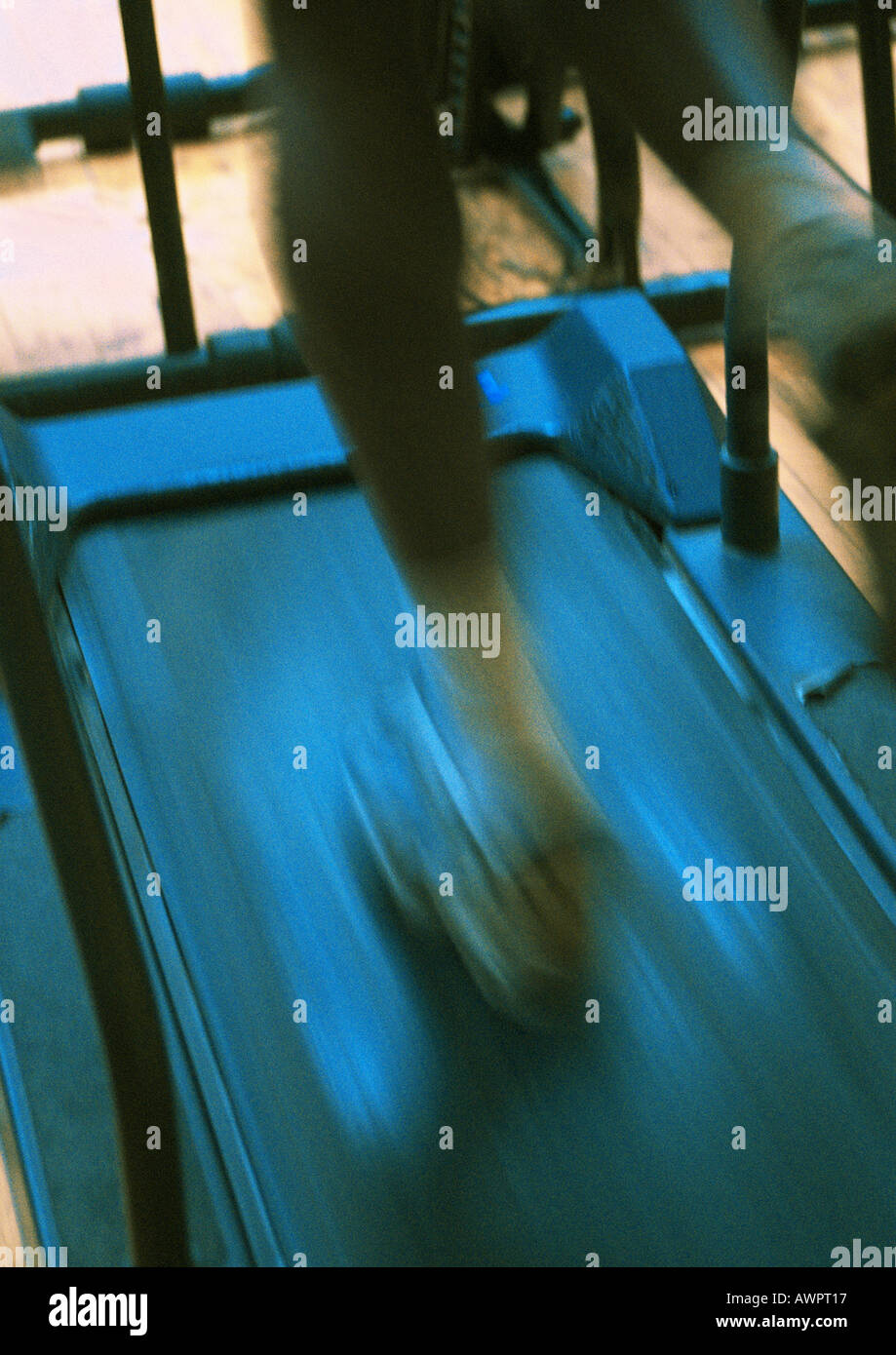 Man running on treadmill, lower section, blurred motion Stock Photo - Alamy