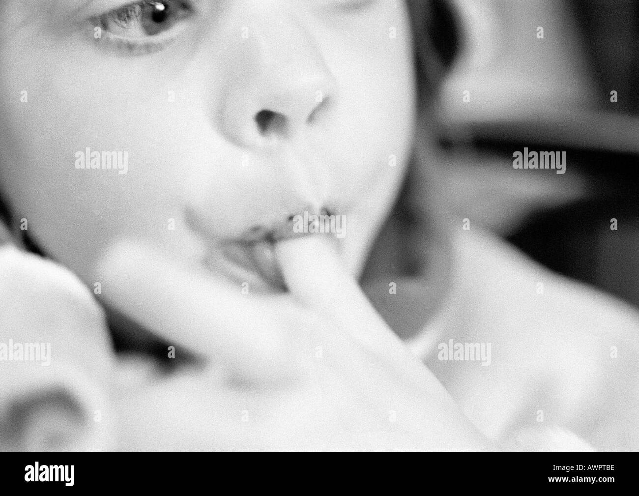Young child eating, finger in mouth, close-up, b&w Stock Photo - Alamy