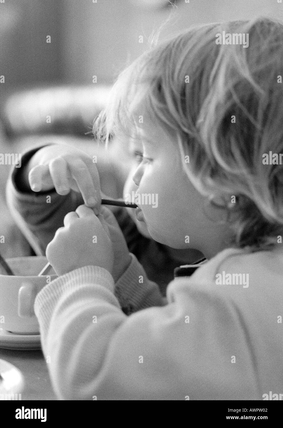 Two children sharing same straw, b&w Stock Photo - Alamy